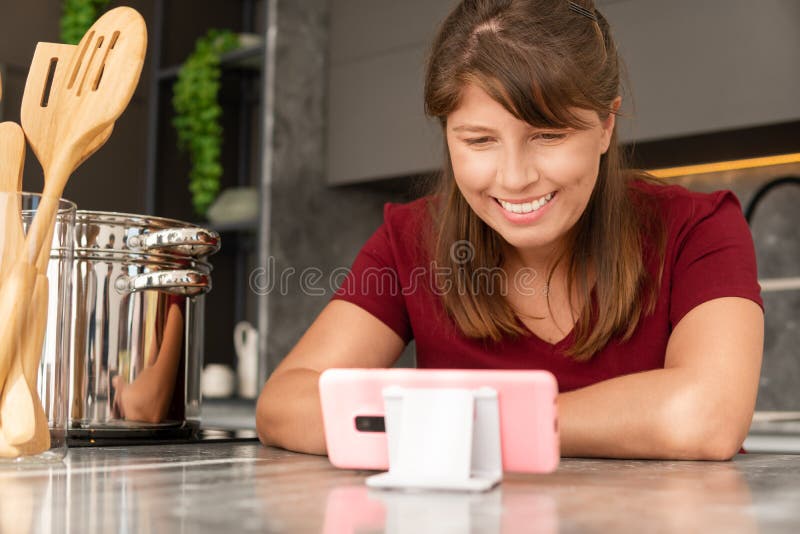 Woman Watching Video on Mobile Phone in the Kitchen Stock Image - Image ...