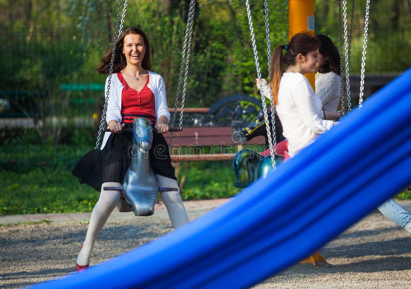 Happy Women Riding on Carousel Stock Image - Image of young, round ...