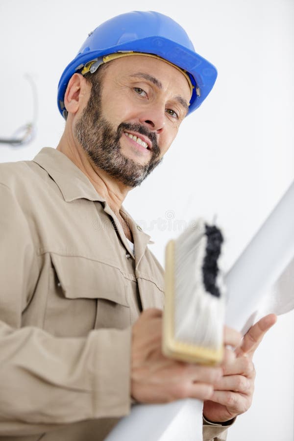 Happy worker with brushes stock image. Image of confidence - 265786709