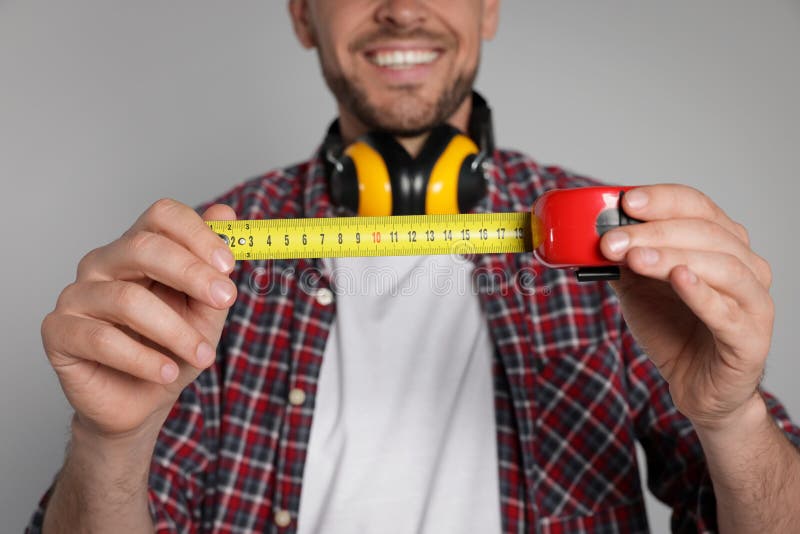 Happy Worker Holding Measuring Tape on White Background, Closeup Stock ...