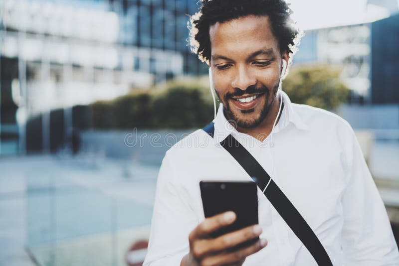 Happy Young African American Man In Headphone Walking At Sunny City And
