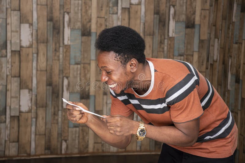 Happy Young African Man Looking at a Piece of Paper Stock Photo - Image ...