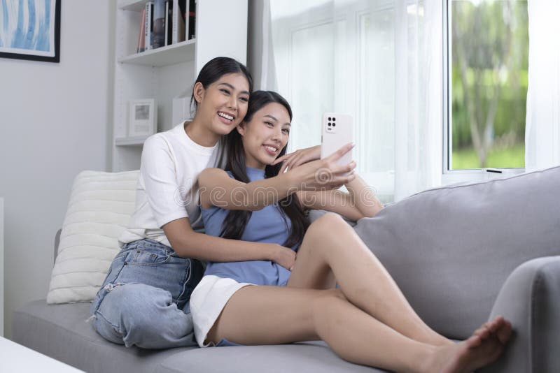 Happy Young Asian Lesbian Couple Taking Selfie In The Living Room Lgbt