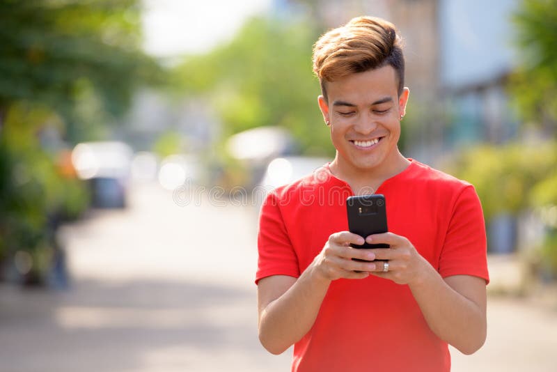 Happy Young Asian Man Using Phone in the Streets Outdoors Stock Photo ...