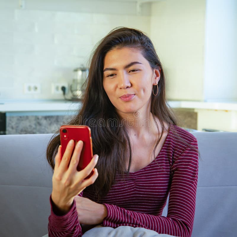 A Happy Young Asian Woman Smiling, Reading and Texting on Her ... A Happy Young Asian Woman Smiling, Reading and Texting on Her ...