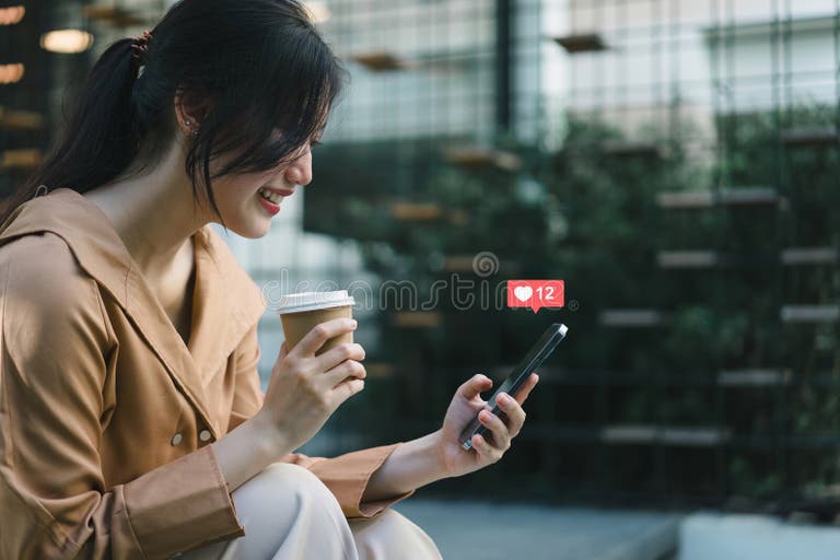 Happy Young Asian Woman Using Smartphone To Interact with Social Media ... Happy Young Asian Woman Using Smartphone To Interact with Social Media ...