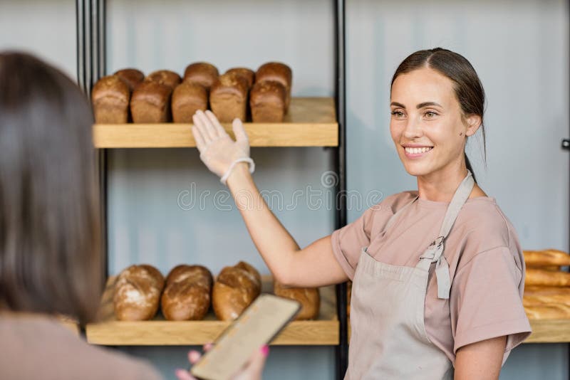 Happy Young Bakery Worker Serving Female Customer with Smartphone Stock ...