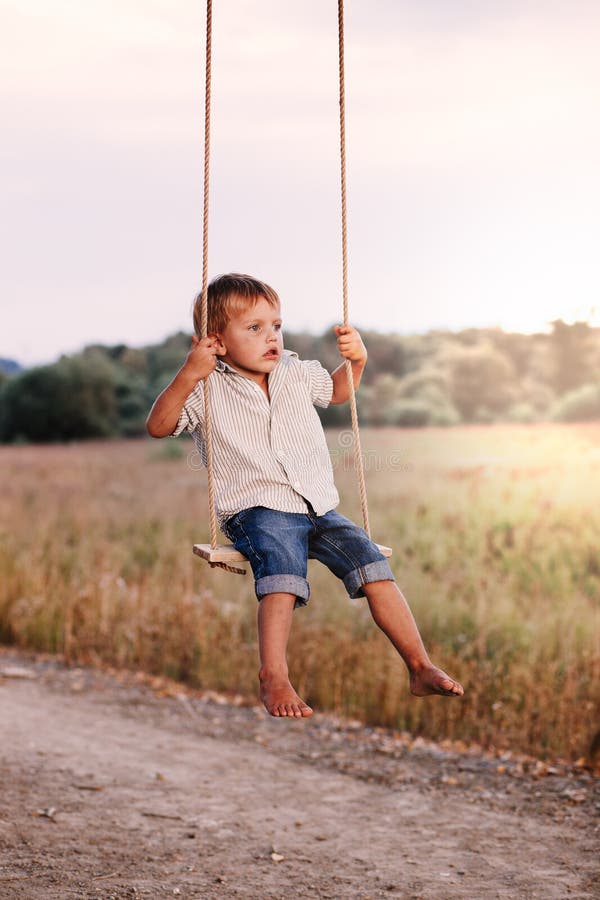 Happy Young Boy Playing on Swing in a Park Stock Image - Image of ...