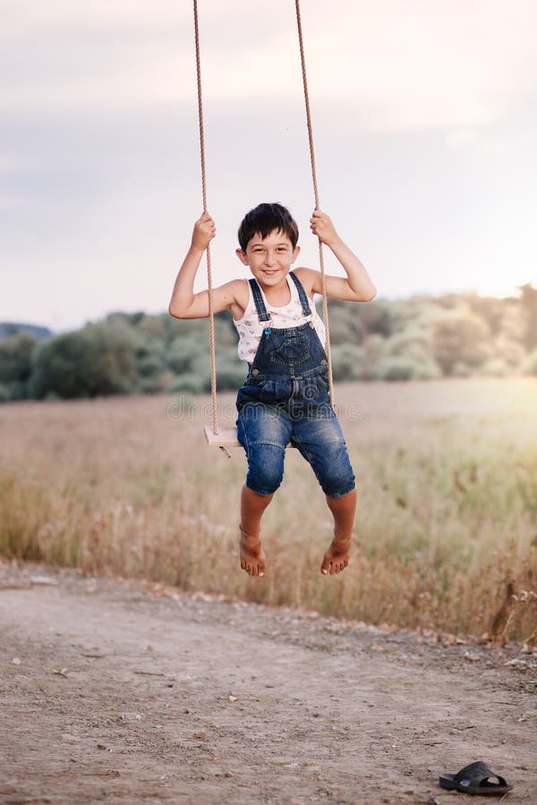 Happy Young Boy Playing on Swing in a Park Stock Image - Image of ...