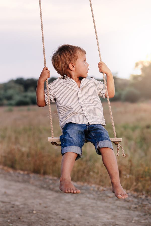 Happy Young Boy Playing on Swing in a Park Stock Photo - Image of happy ...
