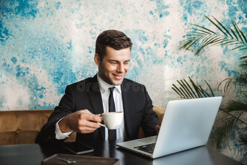Happy Young Businessman Sitting in Cafe Using Laptop Computer Stock ...