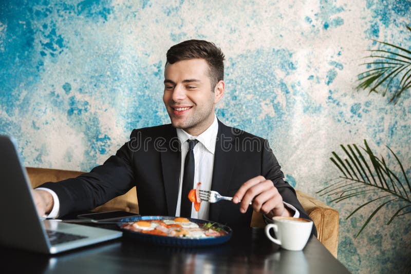 Happy Young Businessman Sitting in Cafe Using Laptop Computer Stock ...