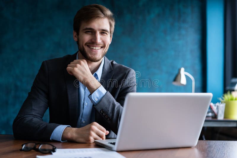 Happy Young Businessman Using Laptop at His Office Desk. Stock Photo ...