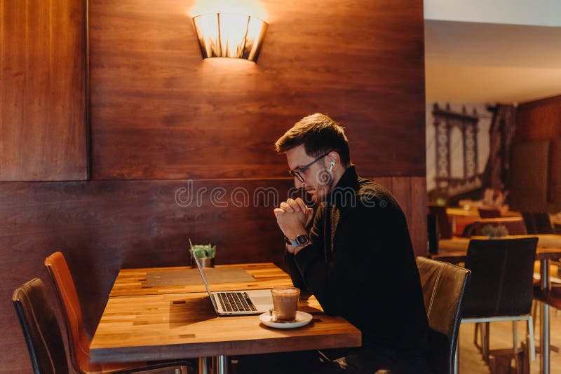 Happy Young Businessman Working on a Laptop in a Cafe Stock Image ...