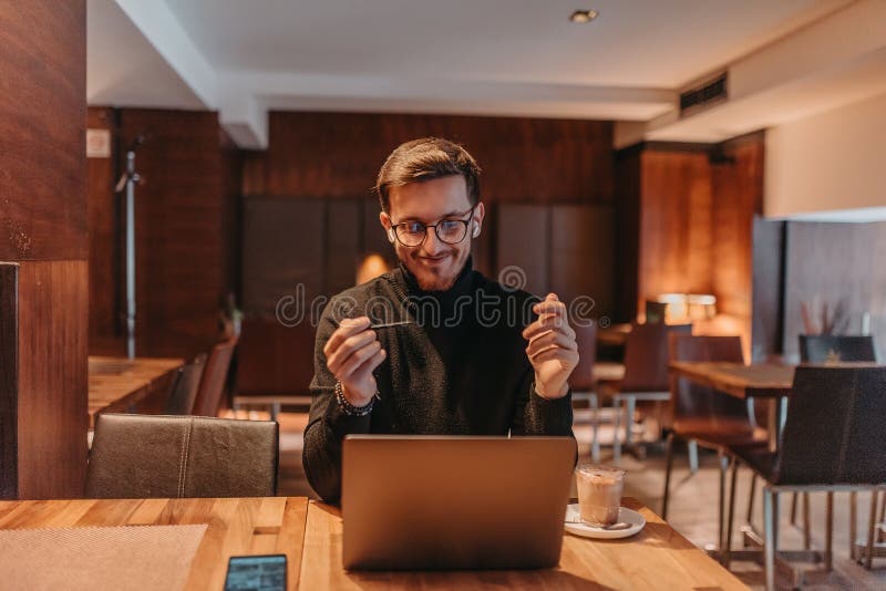 Happy Young Businessman Working on a Laptop in a Cafe Stock Image ...