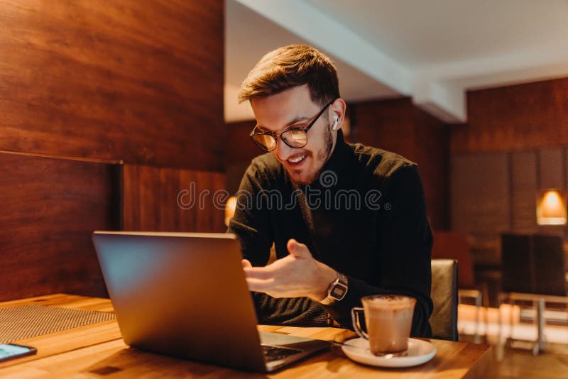 Happy Young Businessman Working on a Laptop in a Cafe Stock Photo ...