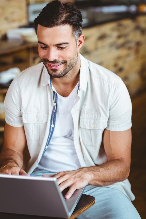 Happy Young Businessman Working at Laptop Drinking Coffee Stock Photo ...