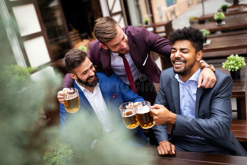 Happy Young Businessmen Drinking Beer and Talking at Pub after Work ...