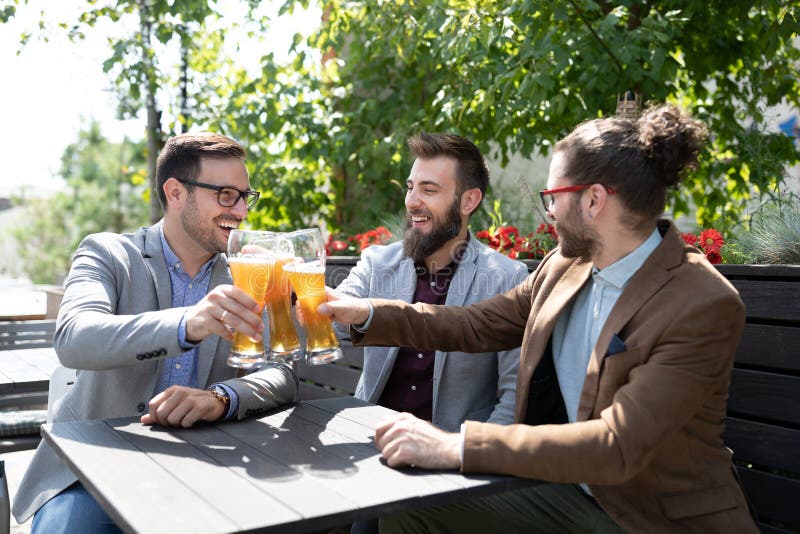 Happy Young Businessmen Drinking Beer and Talking at Pub after Work ...