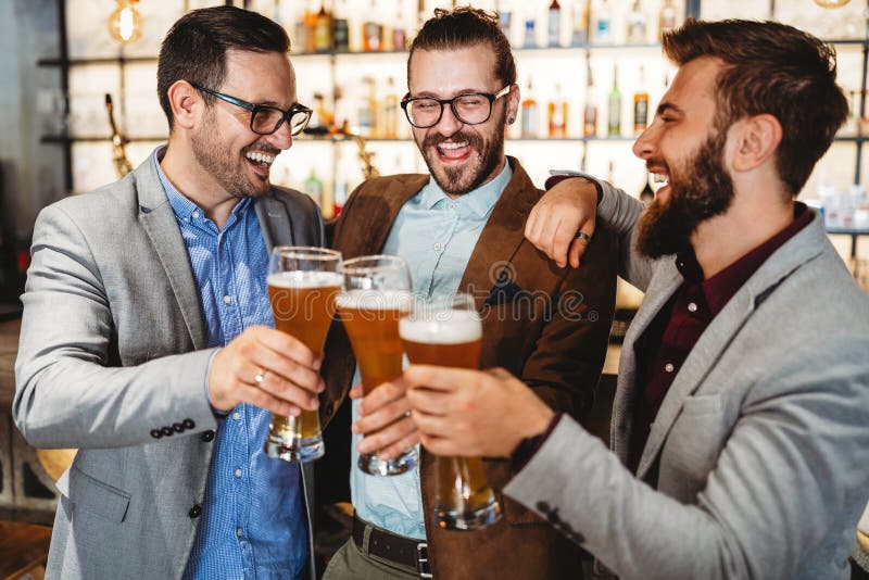 Happy Young Businessmen Drinking Beer and Talking at Pub after Work ...
