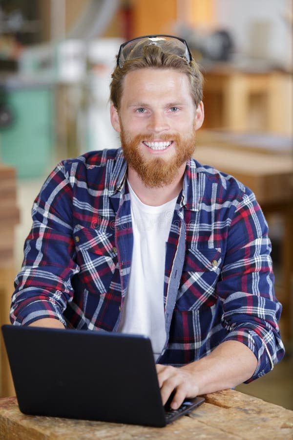 Happy Young Carpenter Enjoying Working on Laptop in Workshop Stock ...