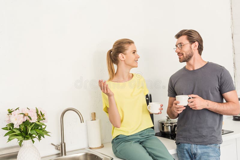 Happy Young Couple with Coffee Cups Talking Stock Photo - Image of ...
