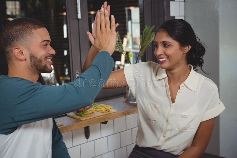 Couple Giving High-five in Cafe Stock Image - Image of relaxation ...