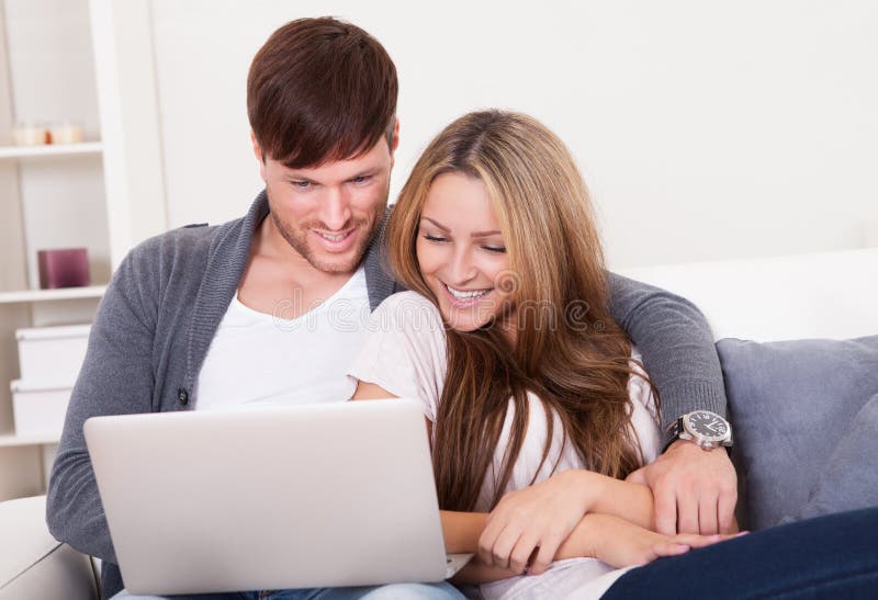 Happy Young Couple Using Computer at Home Stock Photo - Image of ...