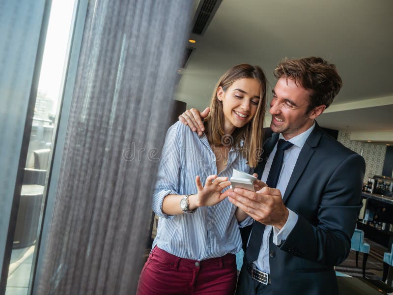 Happy Young Couple Using Mobile Phone, Having a Great Time Together ...