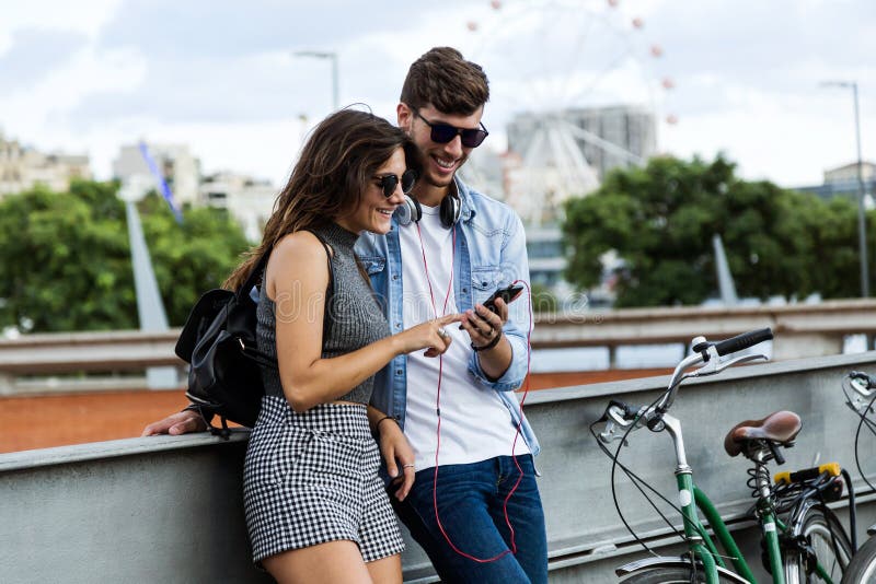 Happy Young Couple Using Mobile Phone in the Street. Stock Image ...