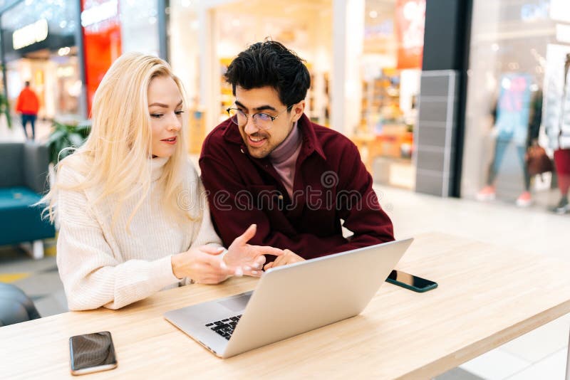 Happy Young Couple Using Typing Laptop Computer Together, Discussing ...