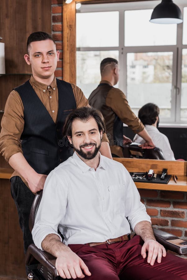 Happy Young Customer and Barber in Barbershop Looking Stock Image ...