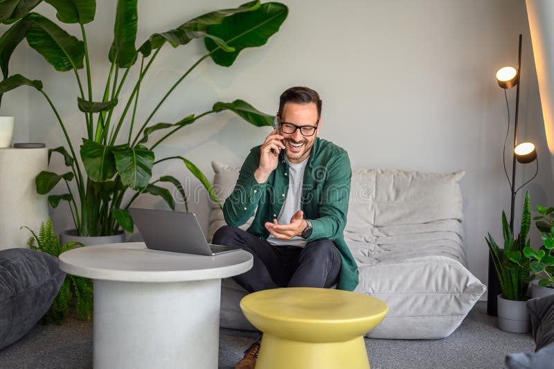 Happy Young Employee Discussing with Client Over Phone Call while ...