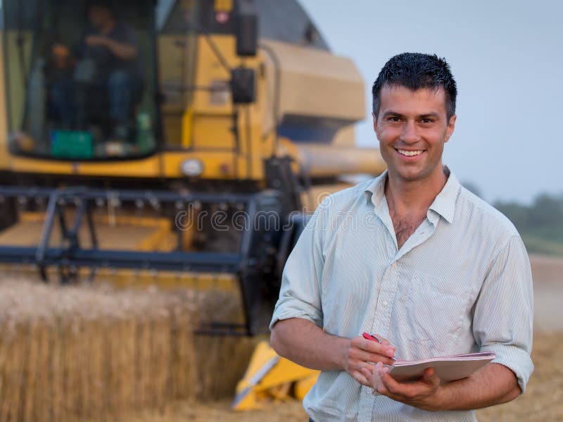 Engineer with Notebook and Combine Harvester in Field Stock Photo ...
