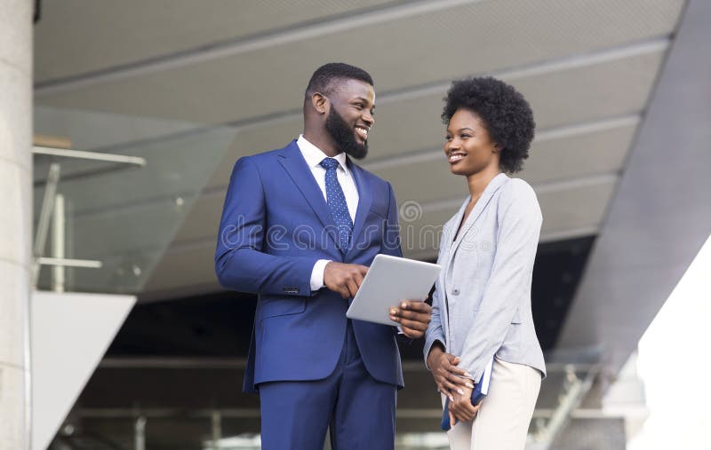 Happy Young Fellow Workers Browsing Internet on Digital Tablet Outdoors ...
