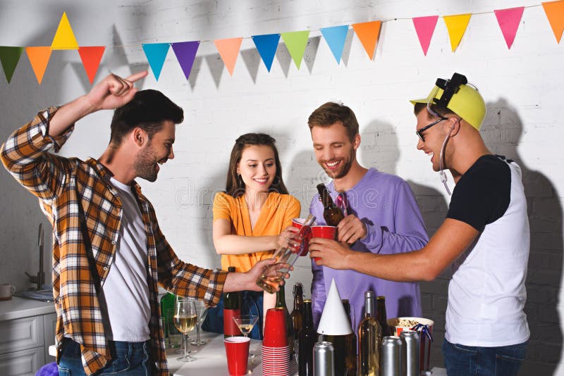 Happy Young Friends Drinking Alcohol while Stock Image - Image of ...