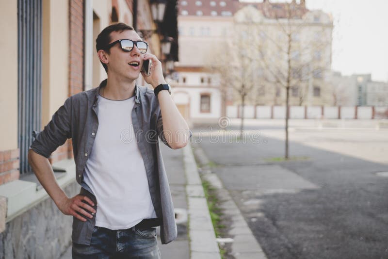 Happy Young Hipster Man Walking on the Street and Talking on Phone ...