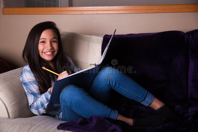 Happy, Young Hispanic Girl Doing Homework on the Couch Stock Image ...