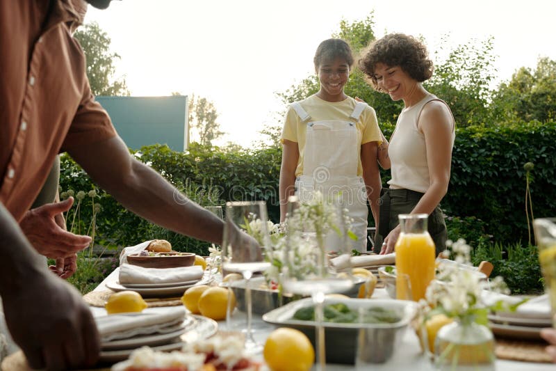Happy Young Intercultural Mother and Daughter Serving Table for Outdoor ... Happy Young Intercultural Mother and Daughter Serving Table for Outdoor ...