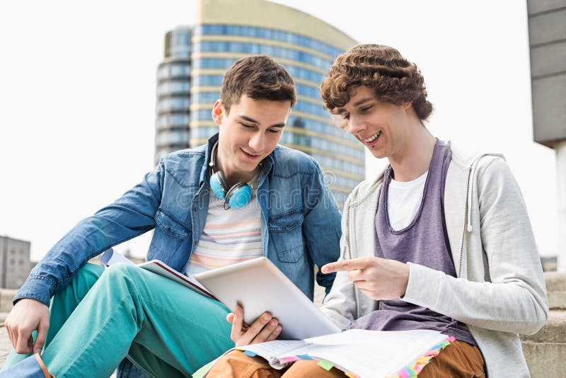 Happy Young Male College Students Using Digital Tablet Against Building ...