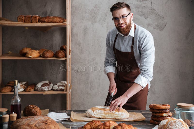 Happy Young Man Baker Standing at Bakery Cut the Bread Stock Image ...