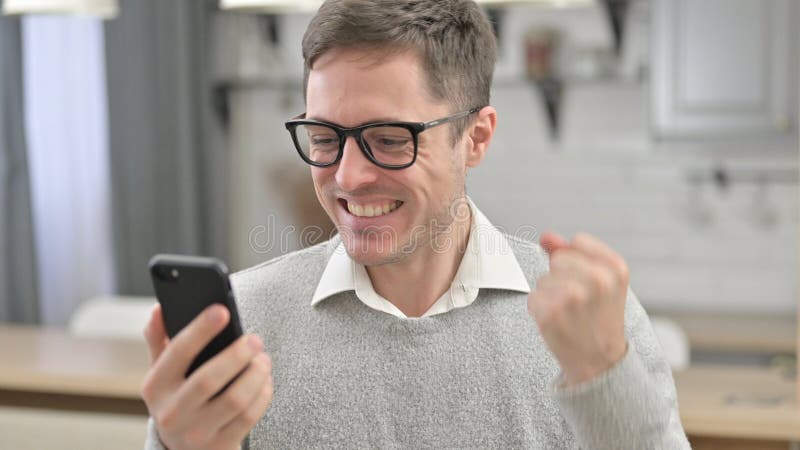 Happy Young Man Celebrating Success on Smartphone Stock Image - Image ...