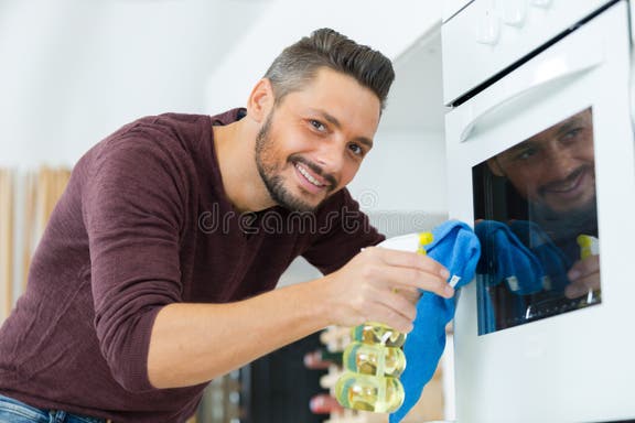 Happy Young Man Cleaning Oven with Rag Stock Image - Image of kitchen ...