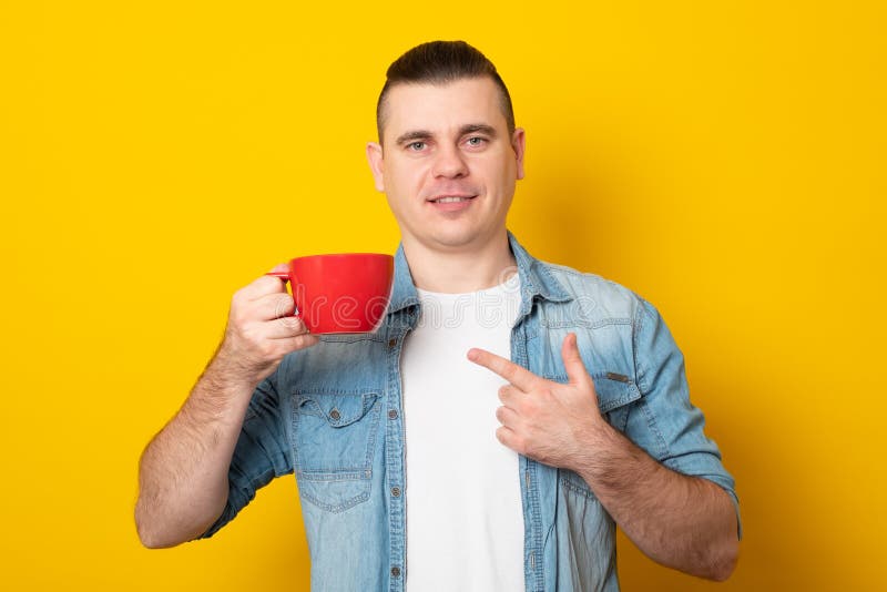 Happy Young Man Holding a Red Mug. Man Drinking from a Large Red Mug ...