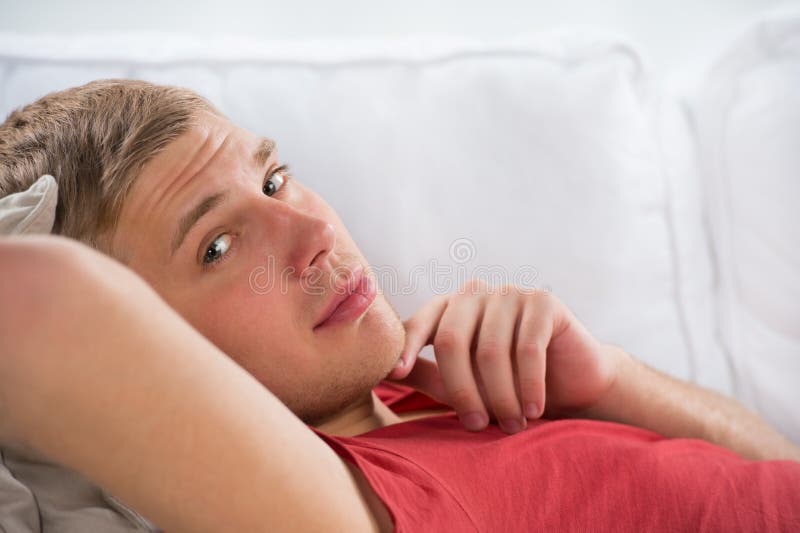 Happy Young Man Laying on Sofa Thinking Stock Image - Image of ...