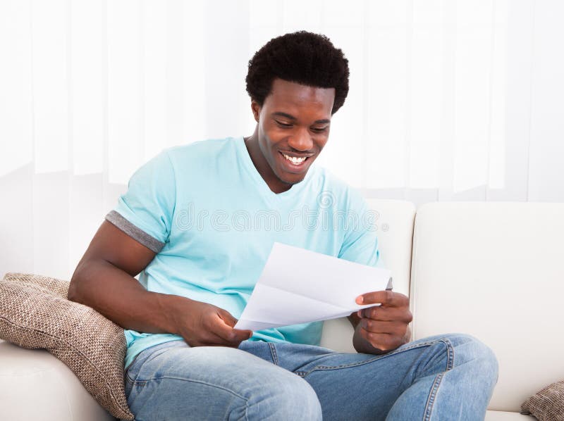 Happy Young Man Looking at Paper Stock Photo - Image of handsome ...