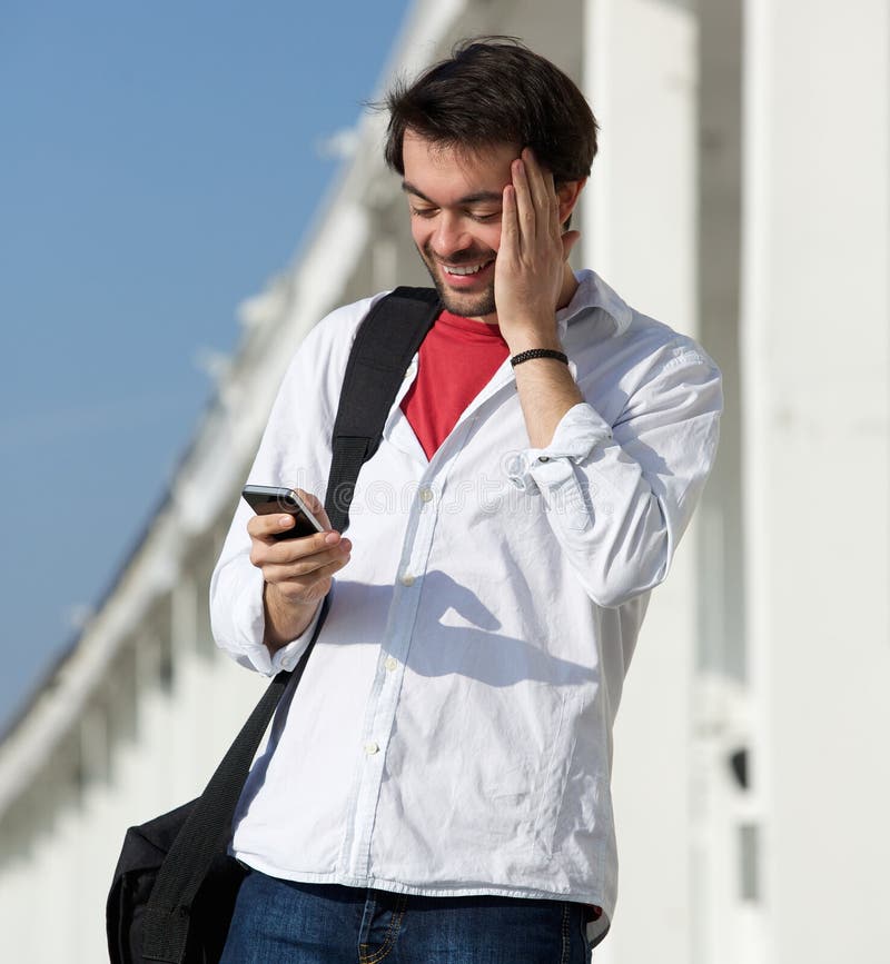 Happy Young Man Reading Text Message on Cell Phone Stock Image - Image ...