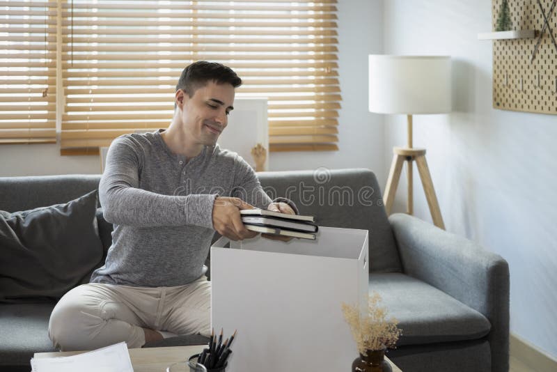 Young Man Sitting on Couch and Preparing Personal Stuff for Removal Day ...