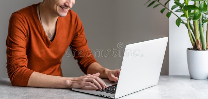 Happy Young Man, Smiling, As he Works on His Laptop Stock Photo - Image ...