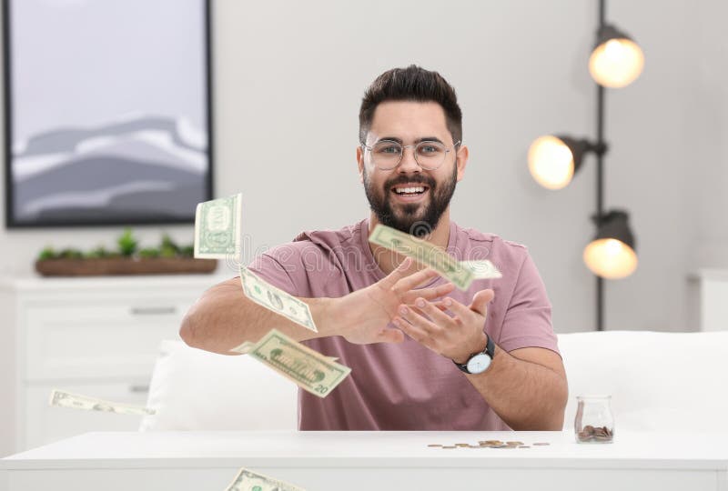 Happy Young Man Throwing Money at White Table Indoors Stock Image ...